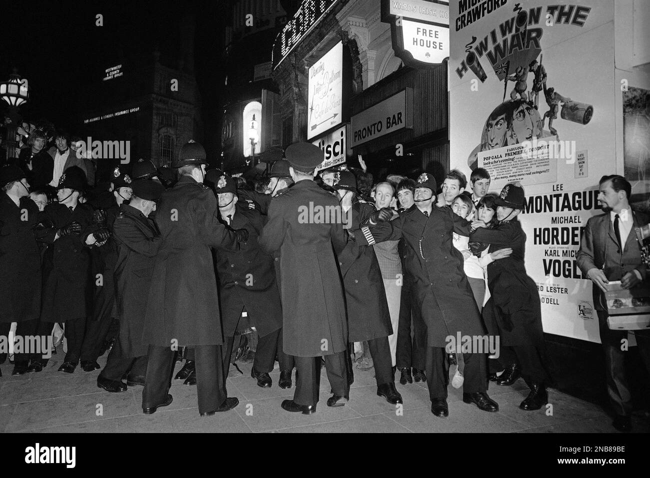 London policemen attempt to contain a surging crowd at the London ...
