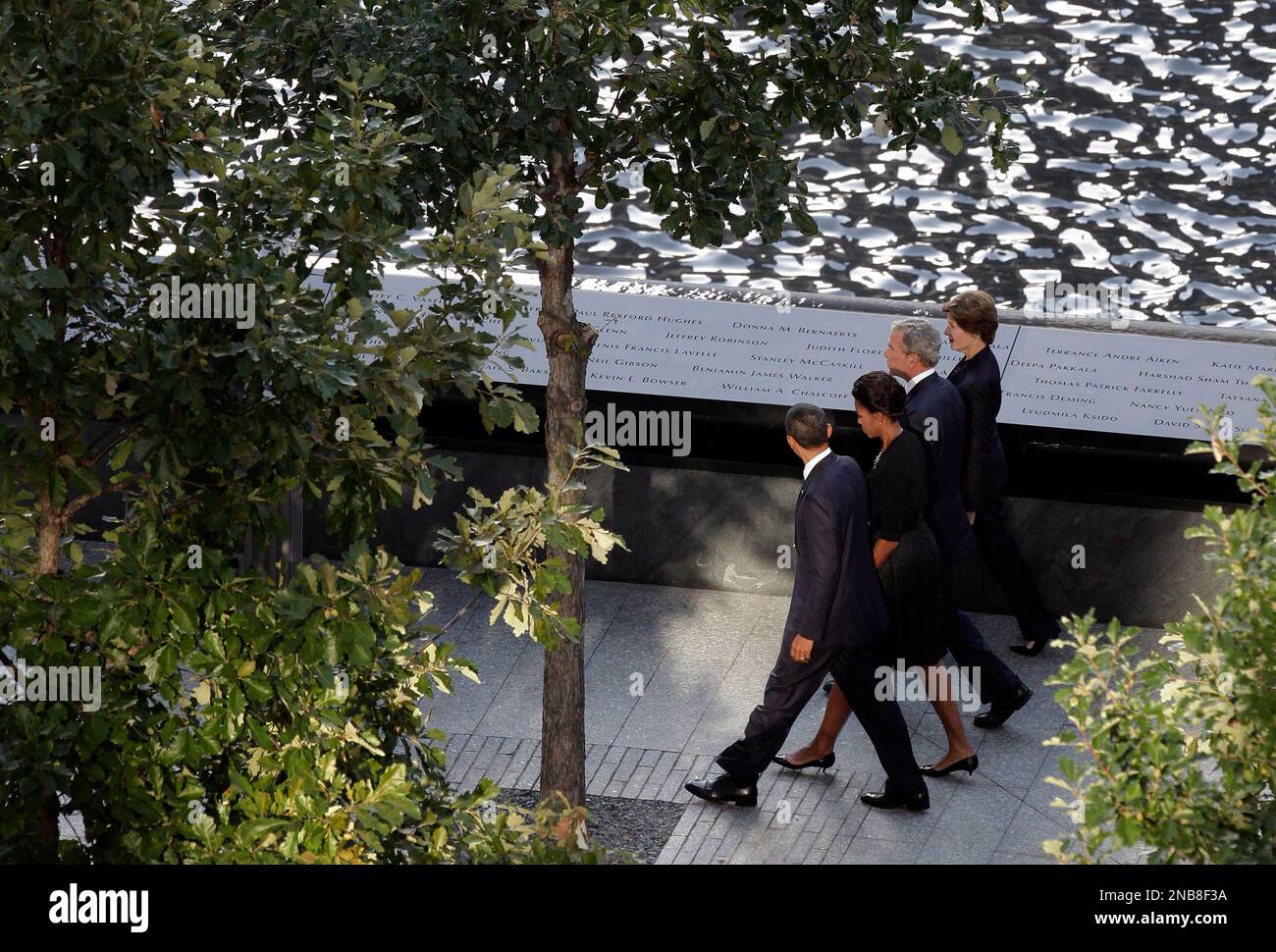 President Barack Obama walks past a reflecting pool near the bronze ...