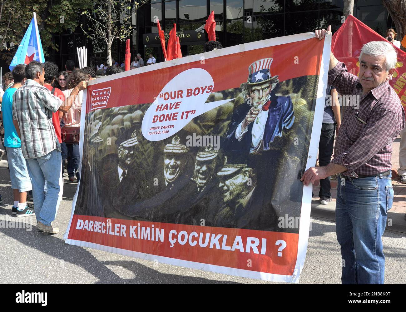 Leftist Turks hold a poster of the military leaders of Turkey's Sept ...