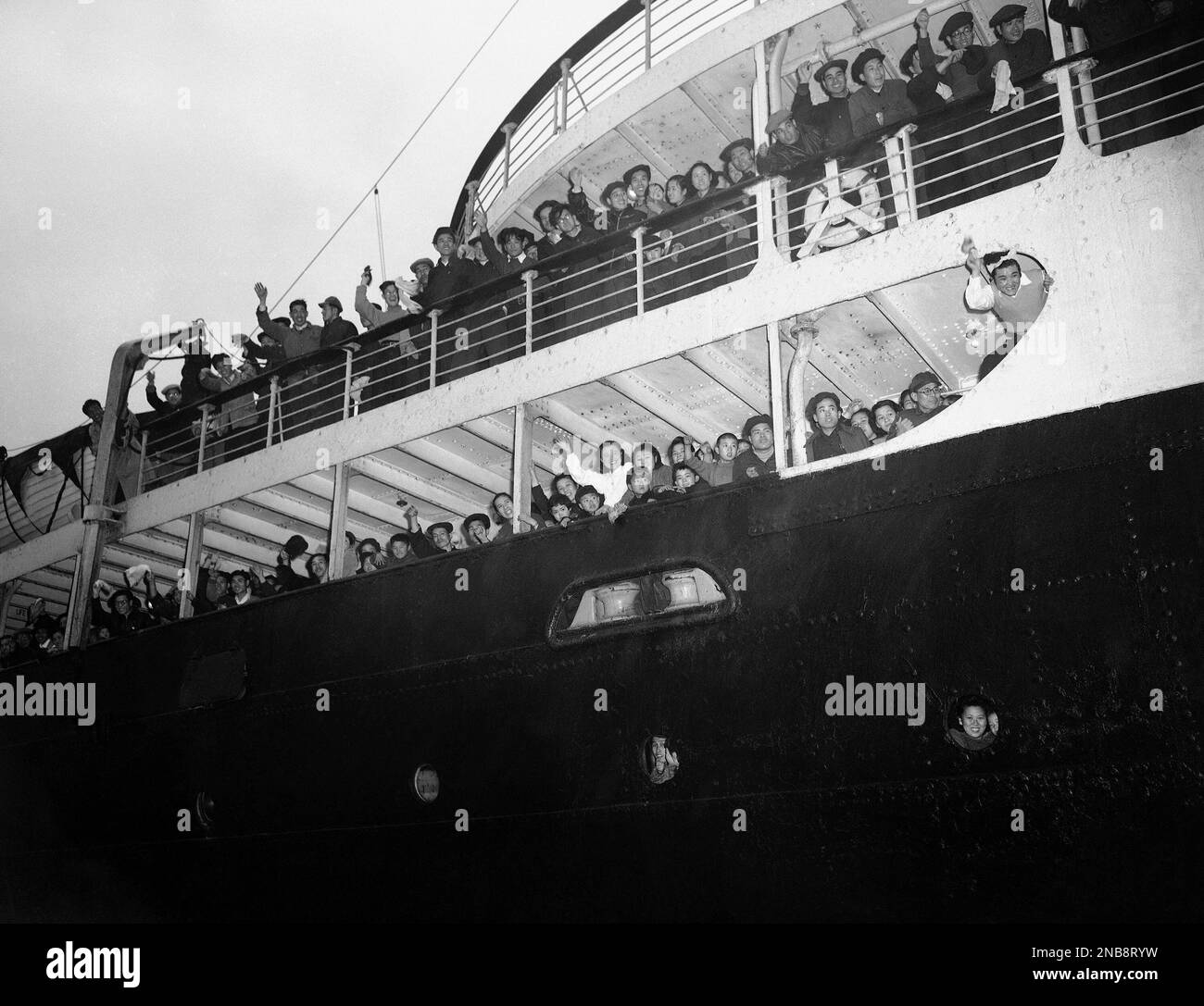 Japanese line the rails of the Koan Maru and wave to the shore in ...