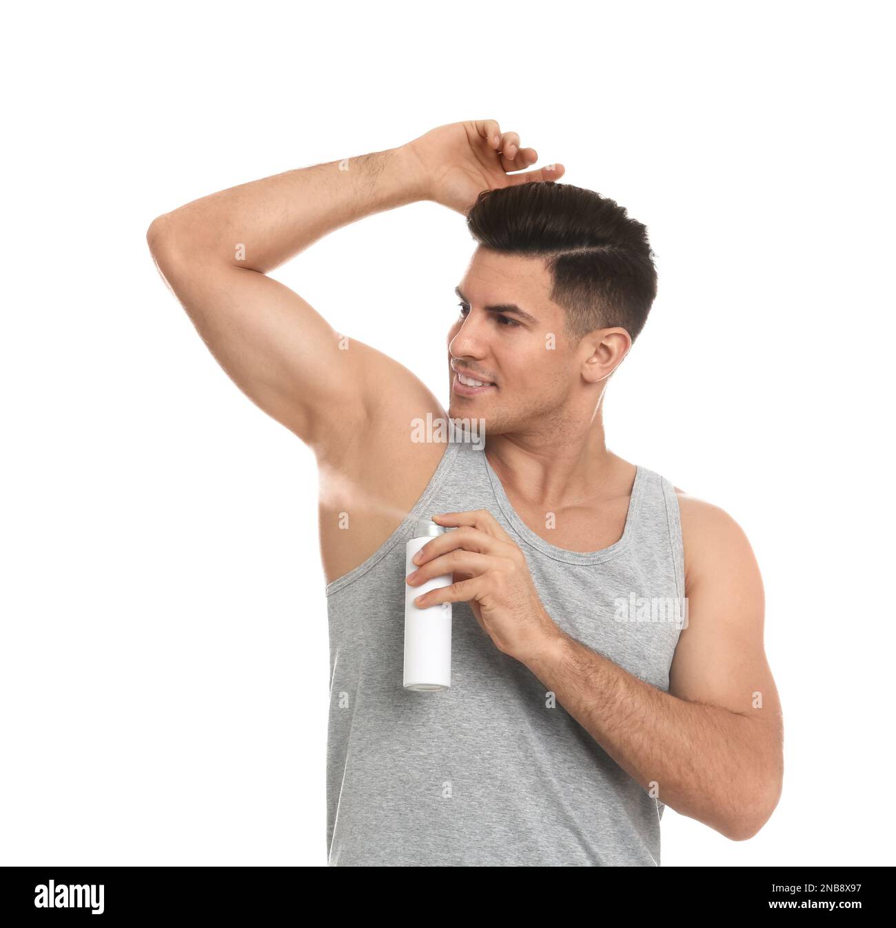 Handsome man applying deodorant to armpit on white background Stock ...