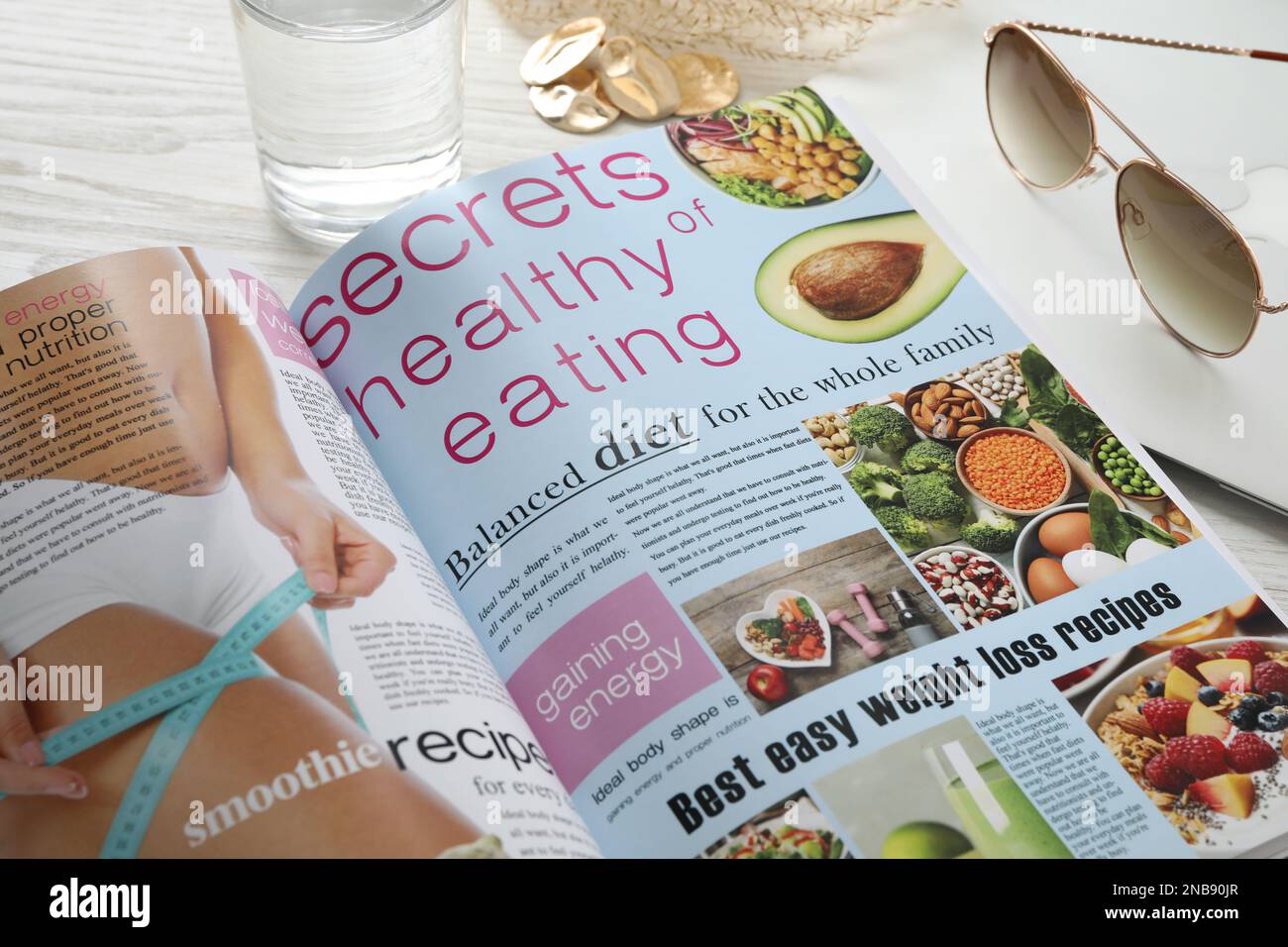 Open healthy food magazine, laptop and accessories on table, closeup ...