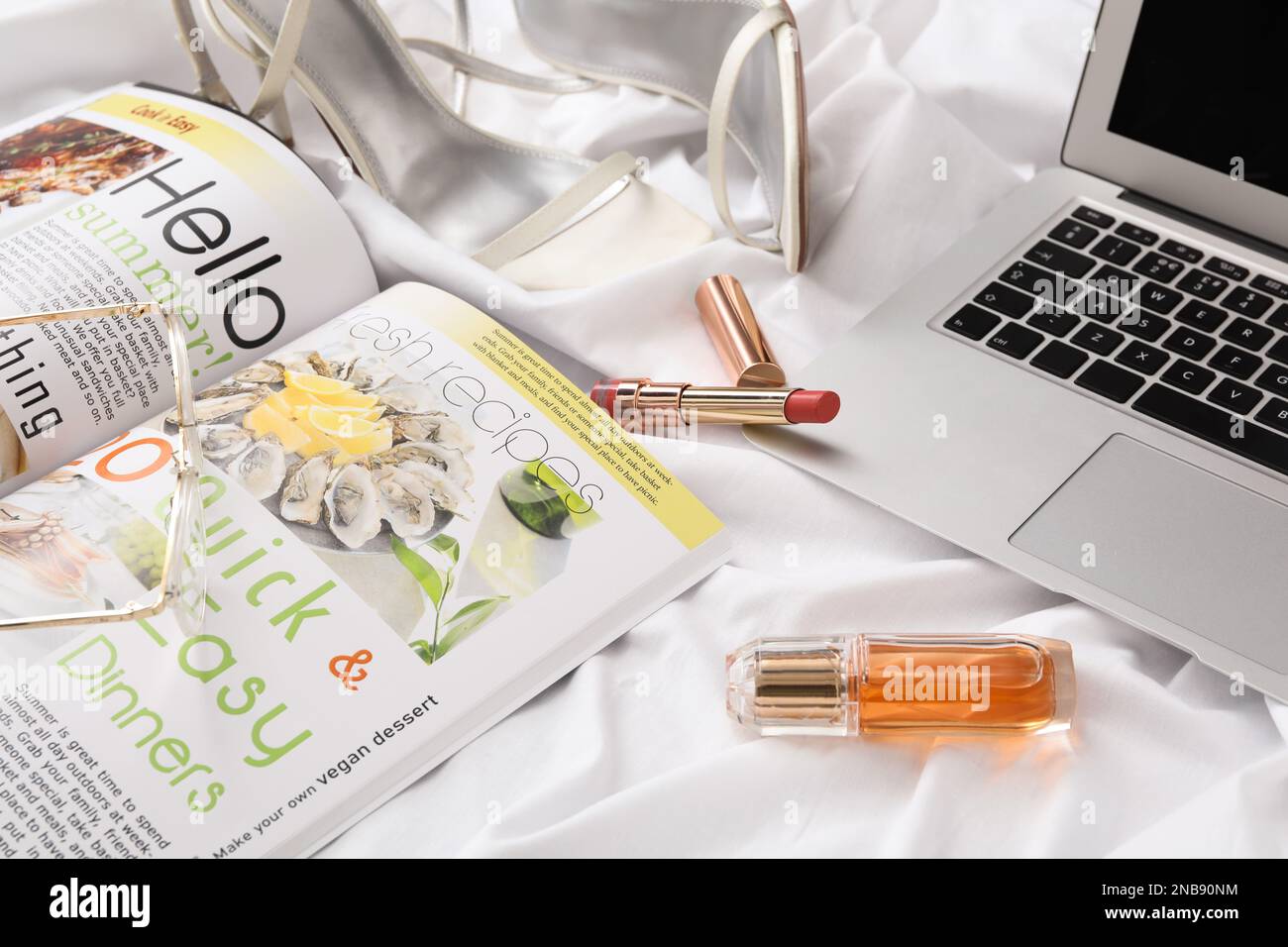 Open healthy food magazine, laptop and accessories on white fabric ...