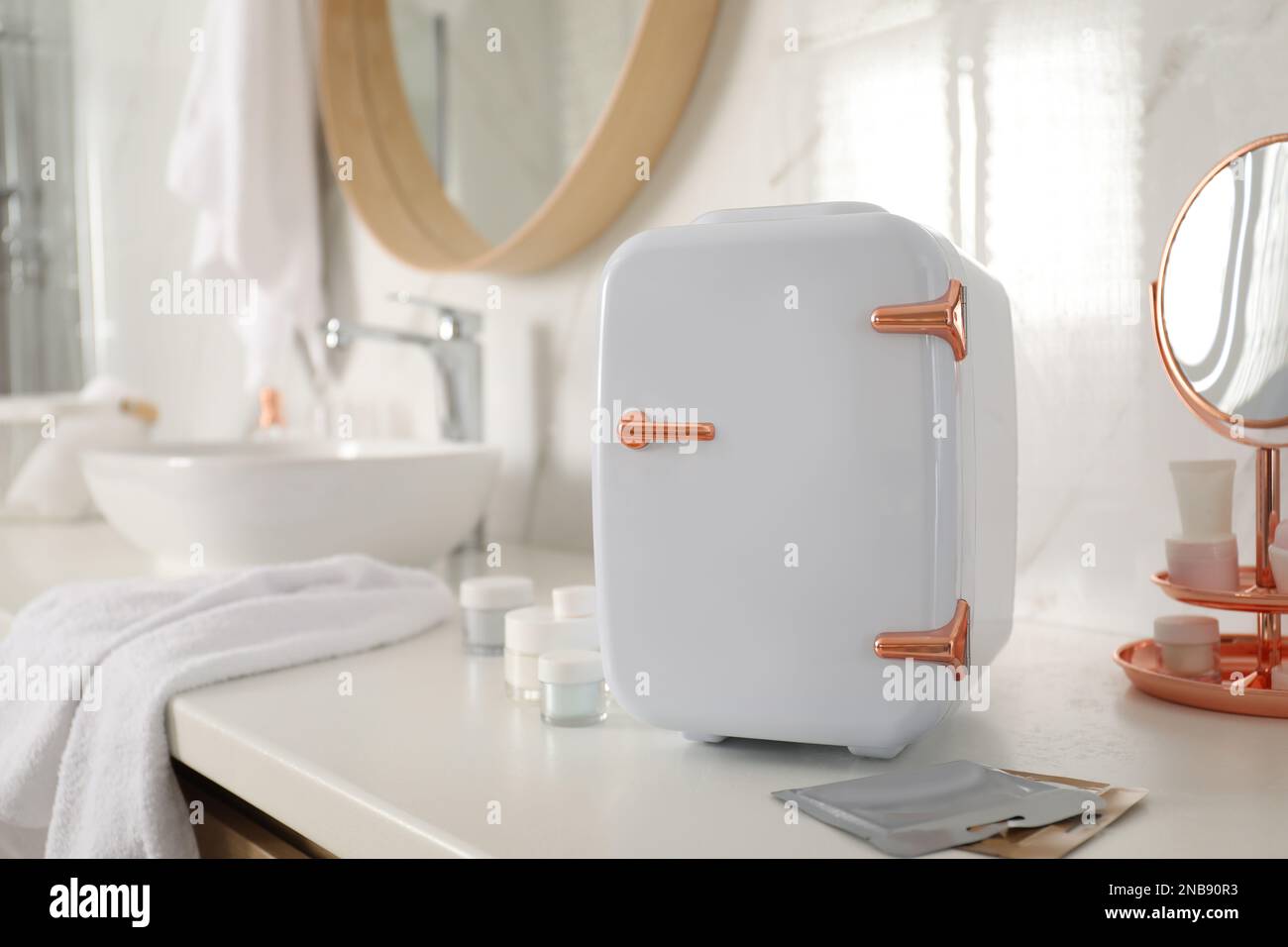 Cosmetics refrigerator and skin care products on white countertop in ...