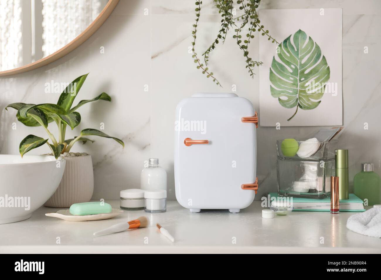 Cosmetics refrigerator and skin care products on white countertop in ...