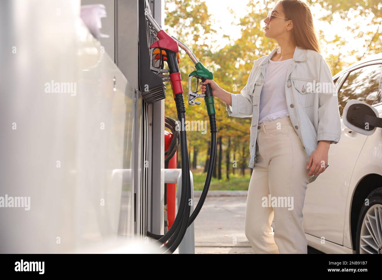 Woman taking fuel pump nozzle at self service gas station Stock Photo ...