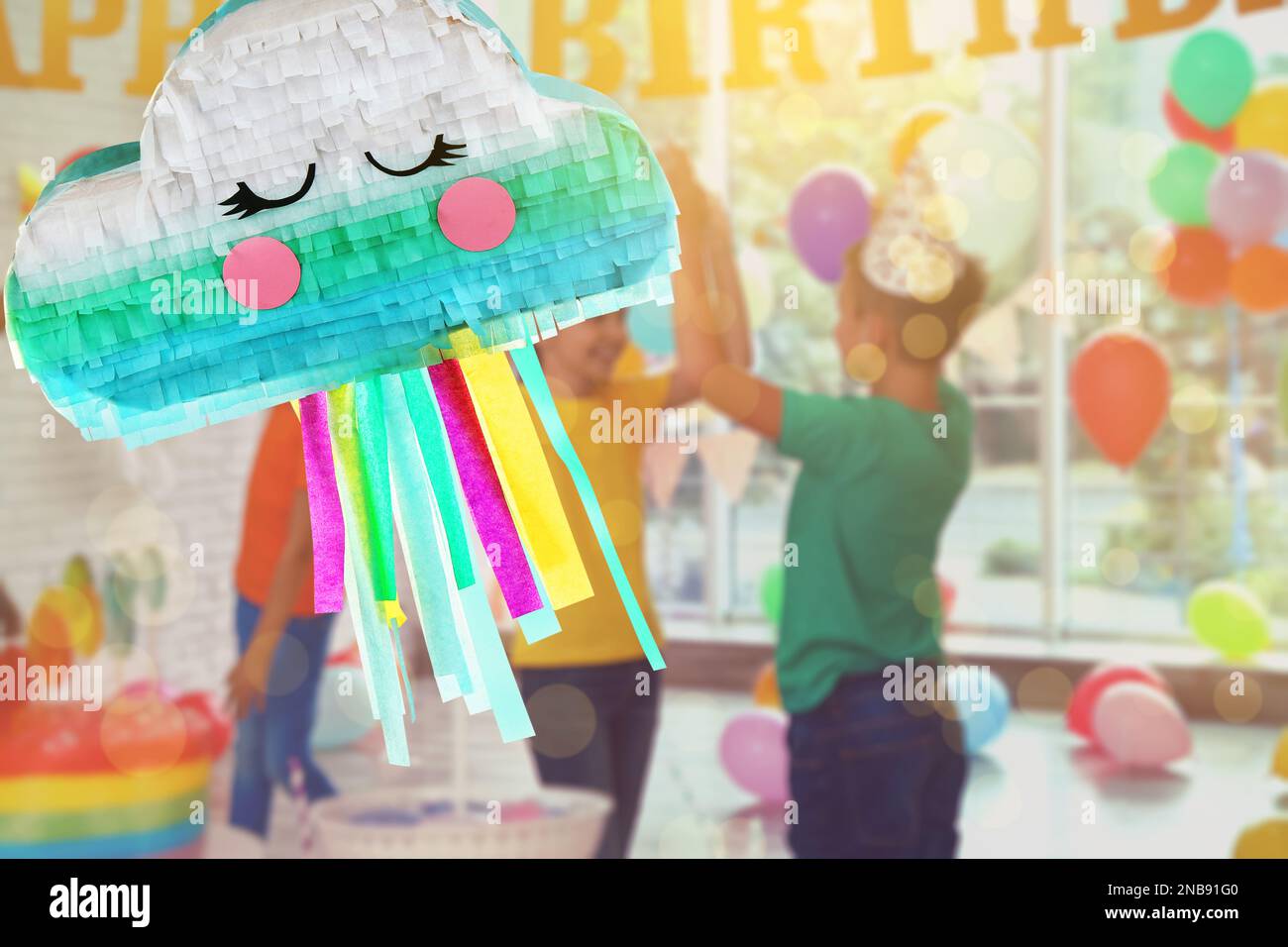 Bright festive pinata hanging indoors at birthday party, space for text ...