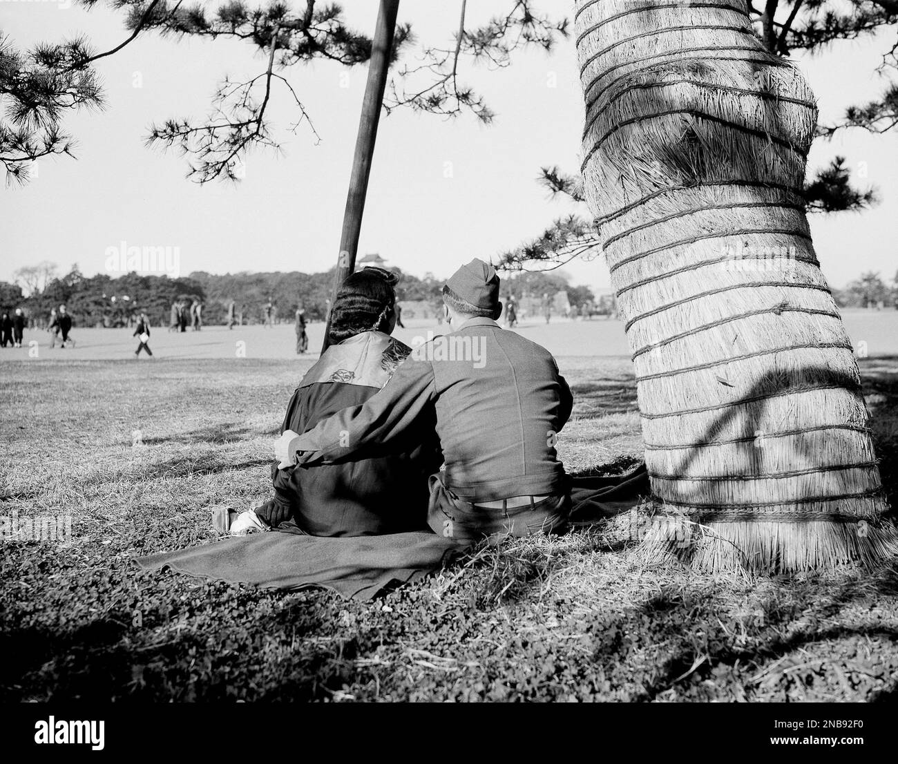 An American G.I. places his arm around a Japanese girl as they view the ...