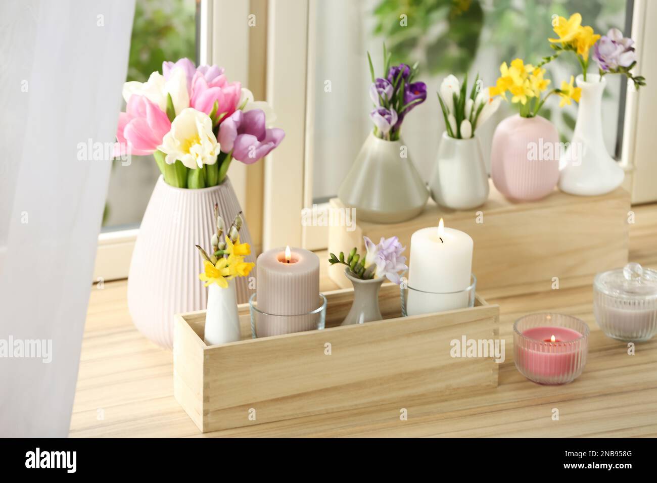 Beautiful spring flowers with burning candles on window sill Stock ...
