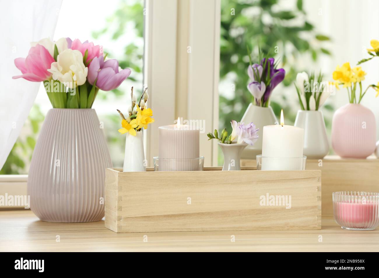Beautiful spring flowers with burning candles on window sill Stock ...