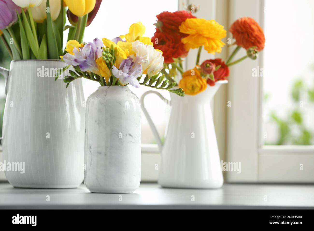 Different beautiful spring flowers on window sill Stock Photo - Alamy
