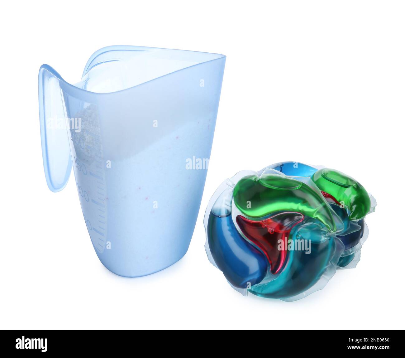 Laundry capsules and measuring cup of washing powder on white ...
