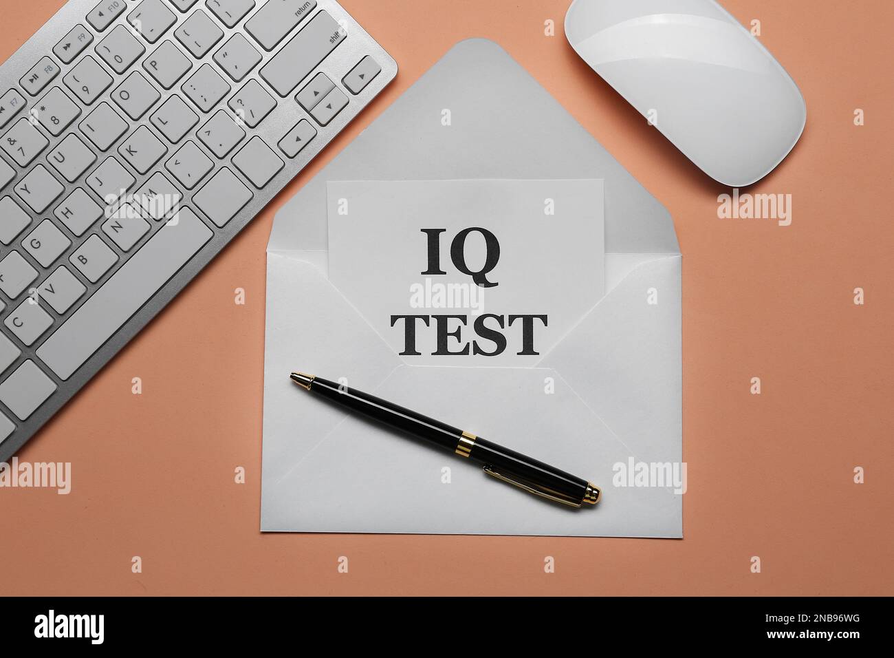 Note with text IQ Test in envelope, keyboard and mouse on coral ...