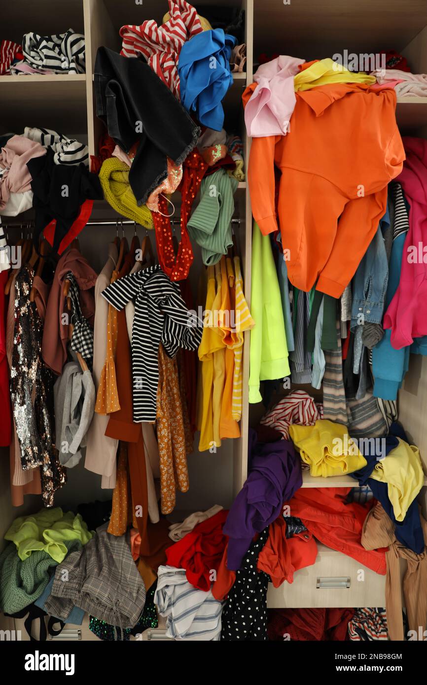 Messy wardrobe with different clothes. Fast fashion concept Stock Photo ...