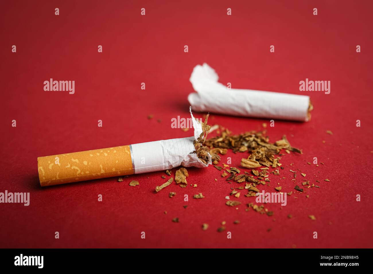 Broken cigarette on red background, closeup. Quitting smoking concept ...