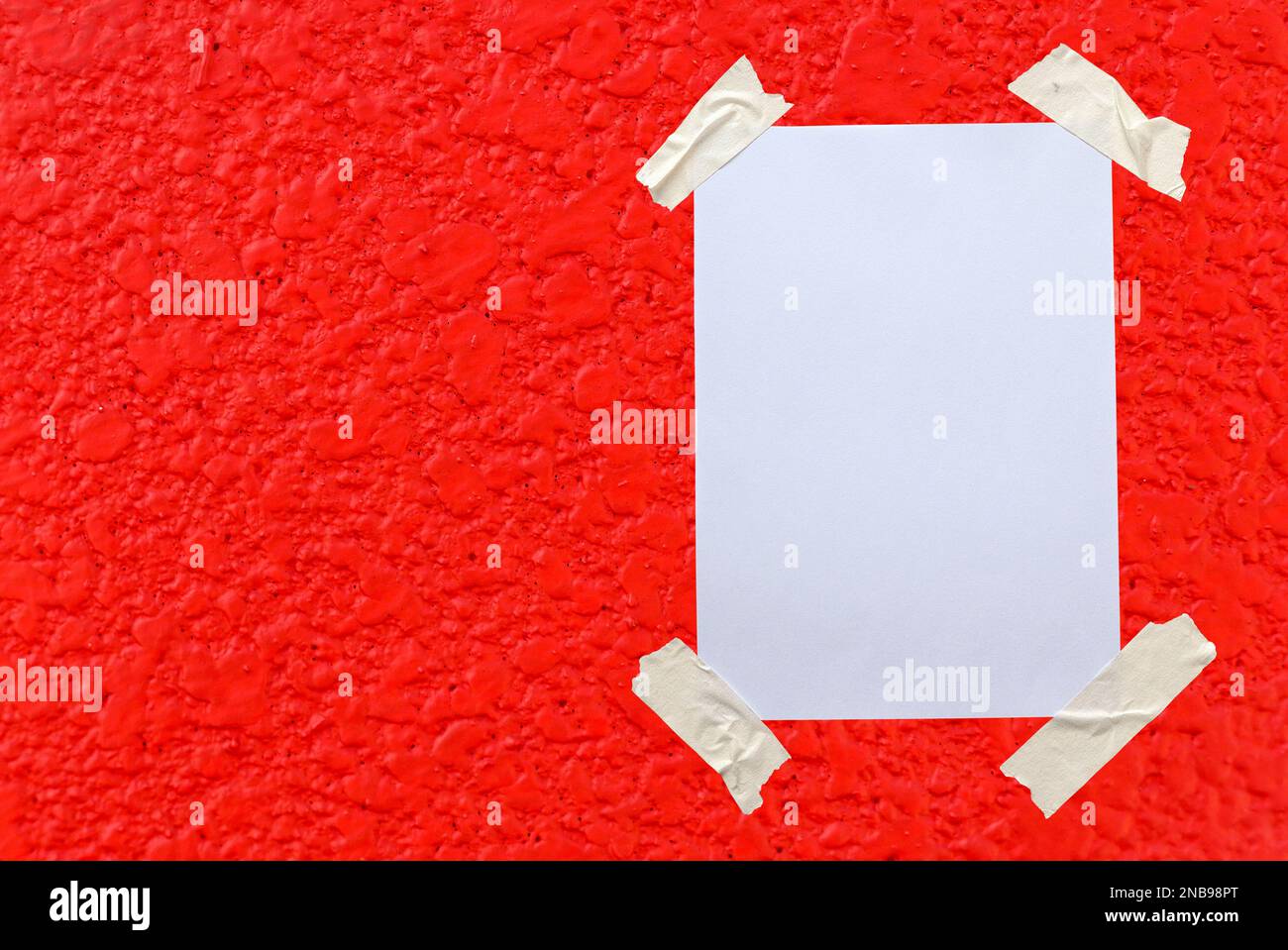 Blank white paper attached to the red wall with tape Stock Photo - Alamy