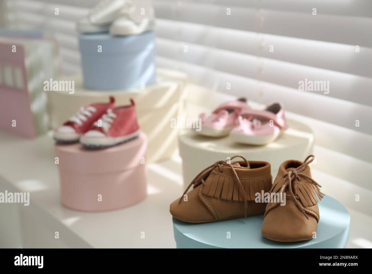 Small baby booties near window in store. Shopping concept Stock Photo ...