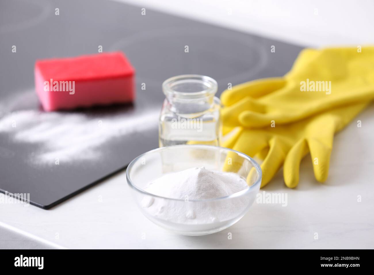 Baking soda, vinegar and gloves on white table. Eco friendly detergent ...