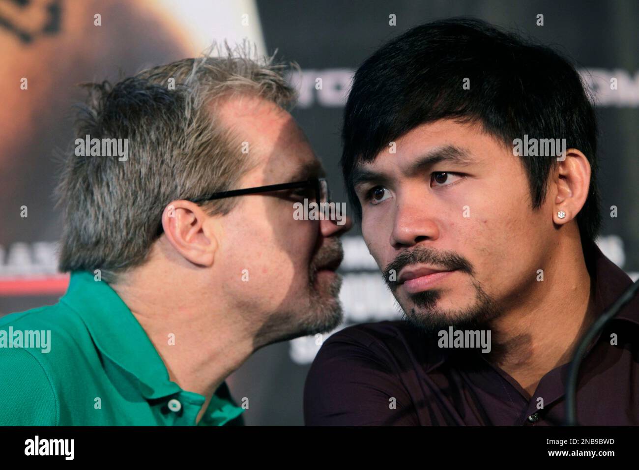 Trainer Freddie Roach, left, whispers to Manny Pacquiao during a news ...