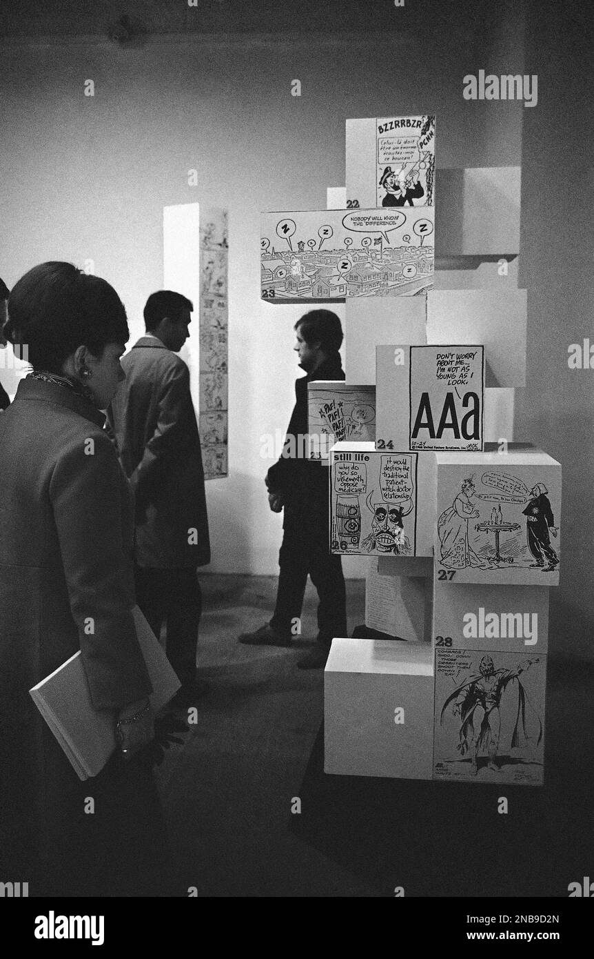 Visitors admire the graphic art blow-ups of comic strips exhibited at ...