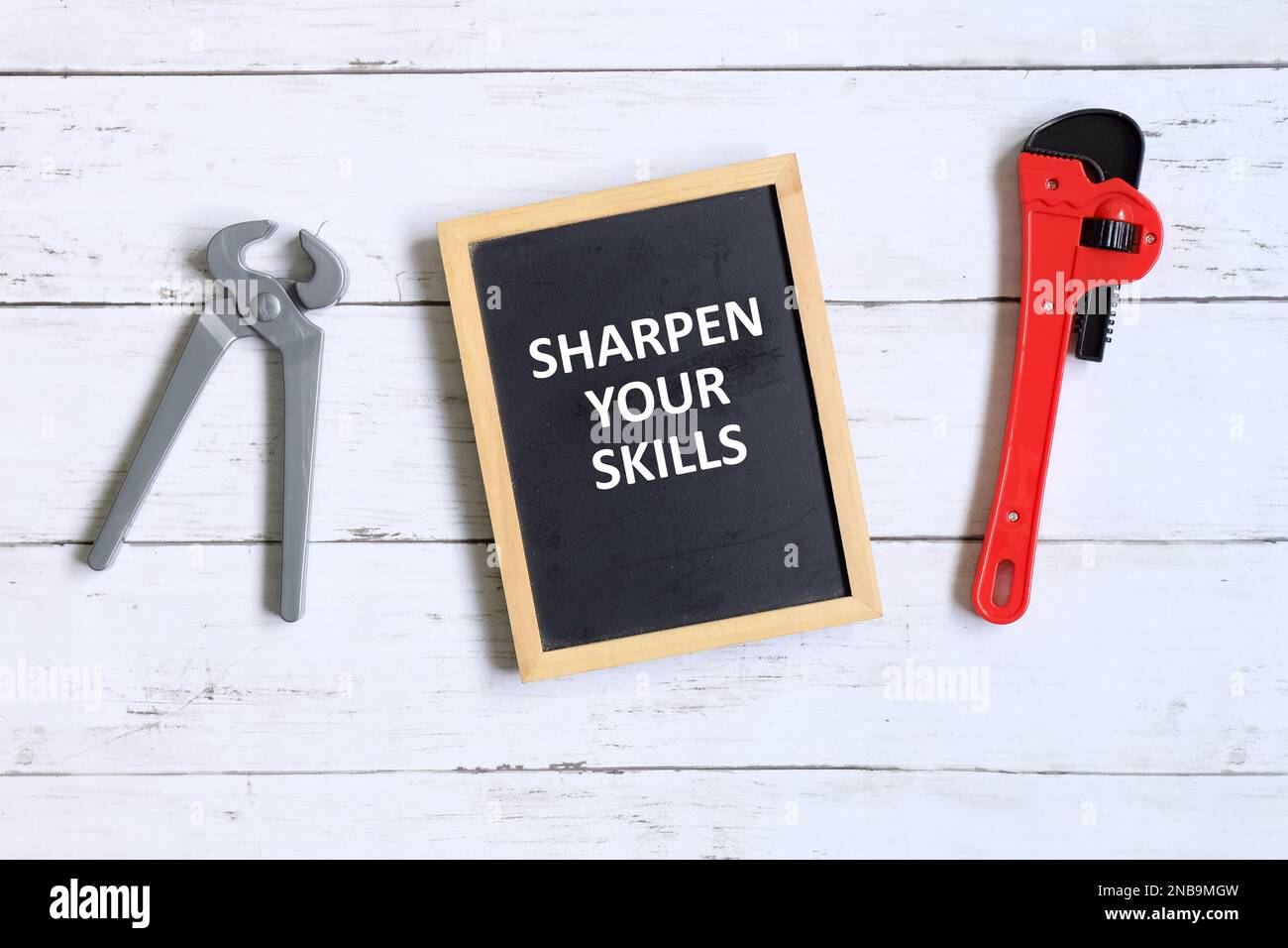 Top view of cutter,wrench and blackboard written with 'SHARPEN YOUR ...