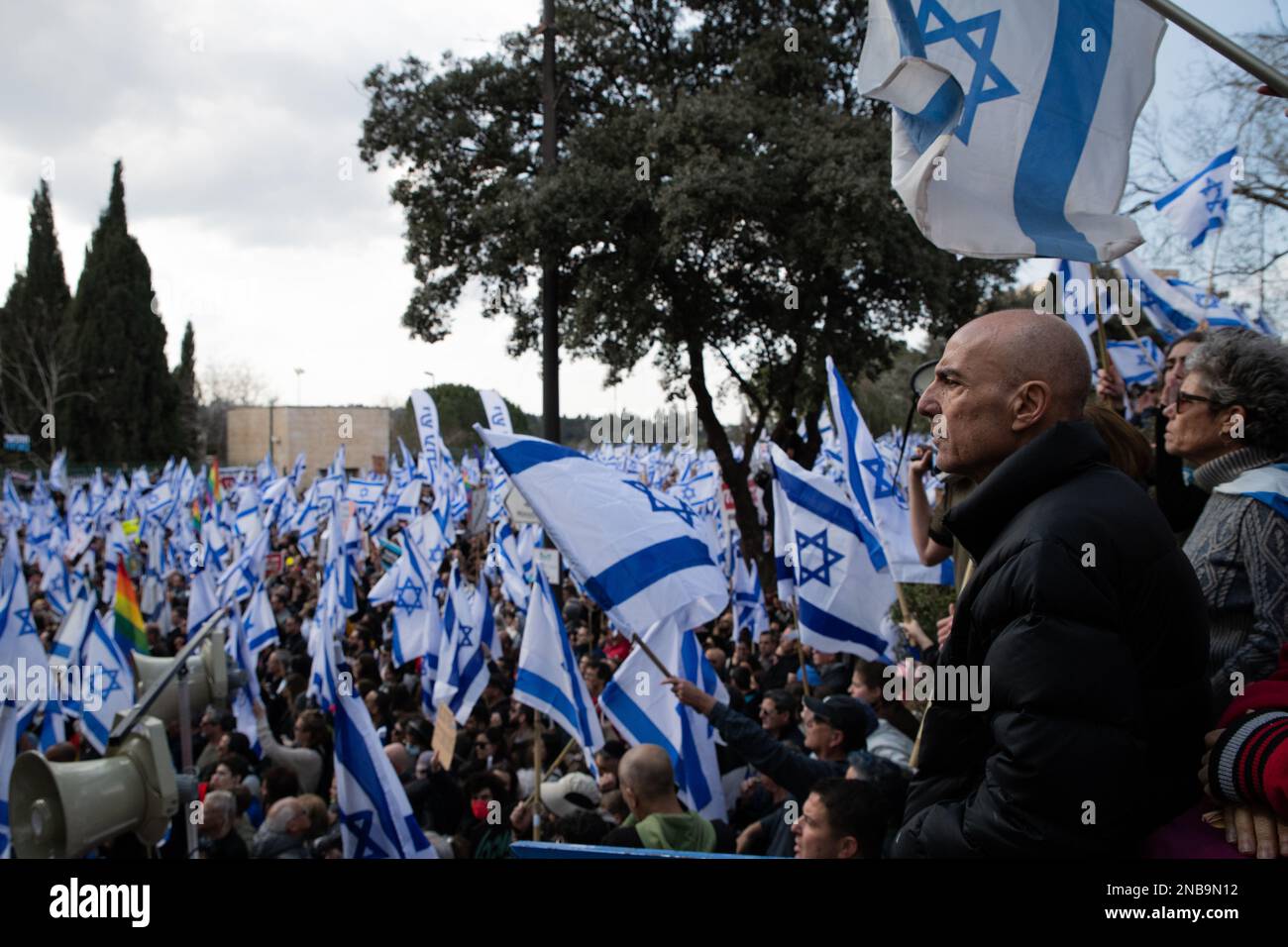 Israel. 13th Feb, 2023. An Israeli man overlooks a crowd of protestors ...