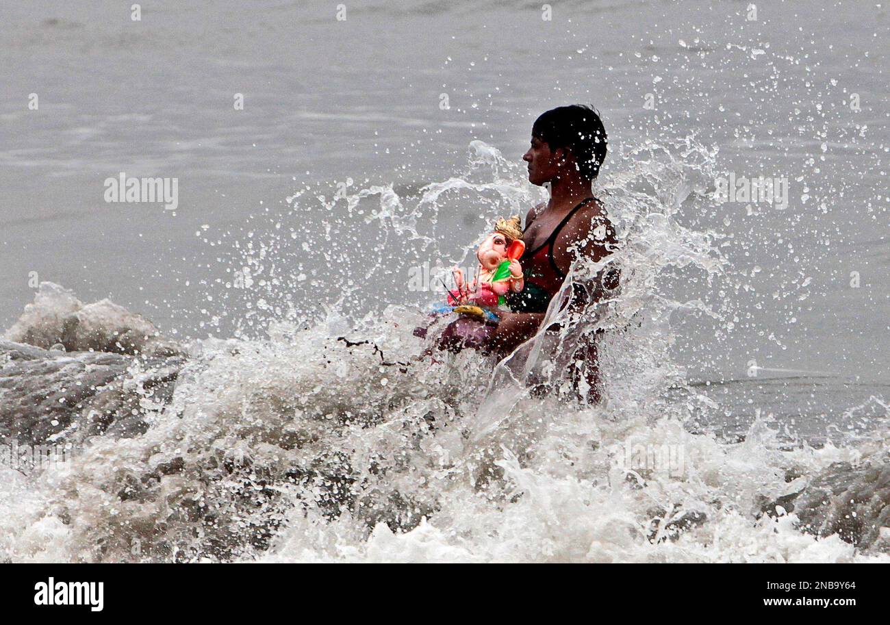A man carries an idol of elephant-headed Hindu God Ganesha for ...