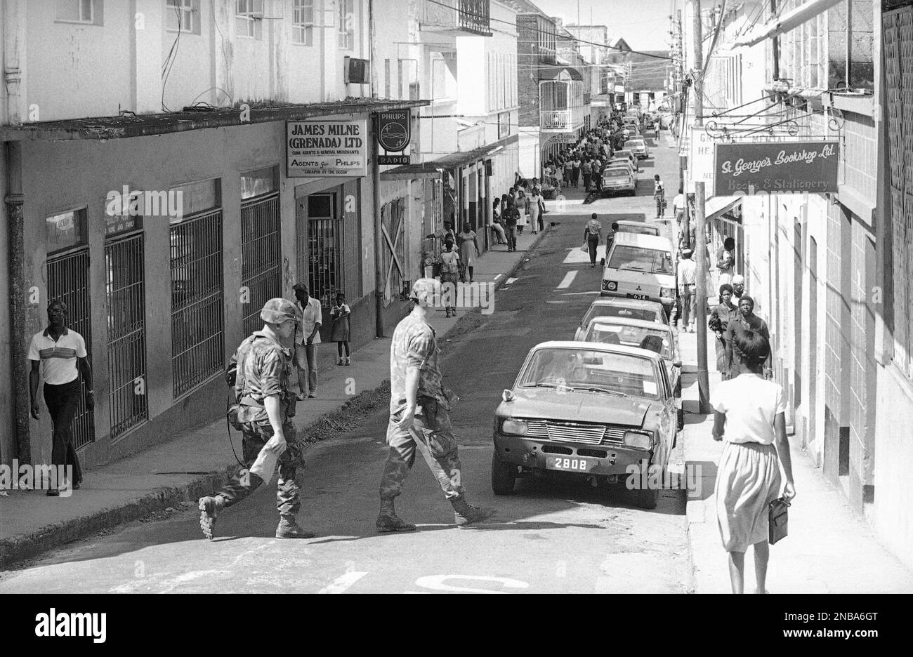 Two U.S. Army soldiers walk down a street in St. George's carrying only ...