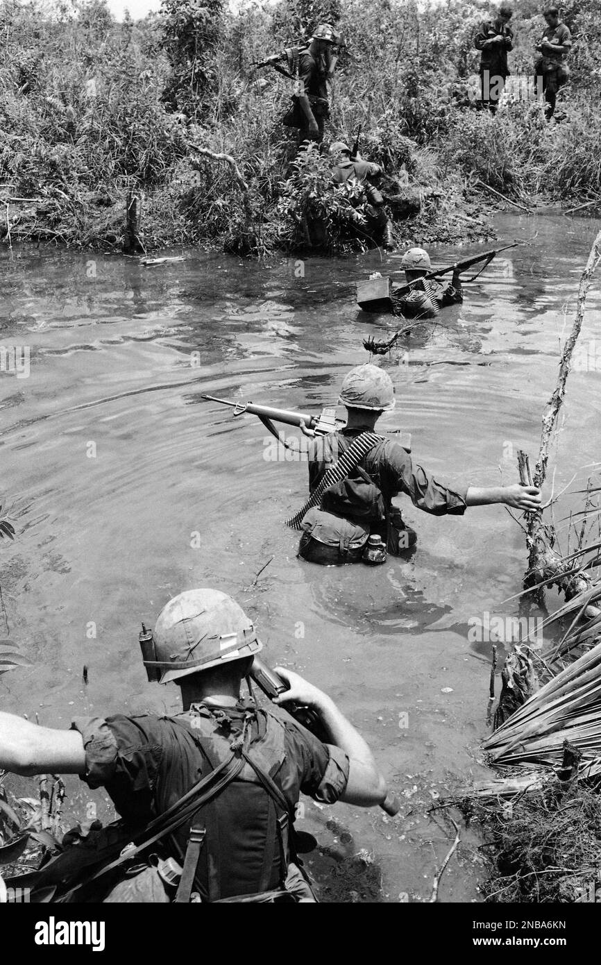 Troops of the U.S. 25th Infantry Division churn through muddy stream in ...
