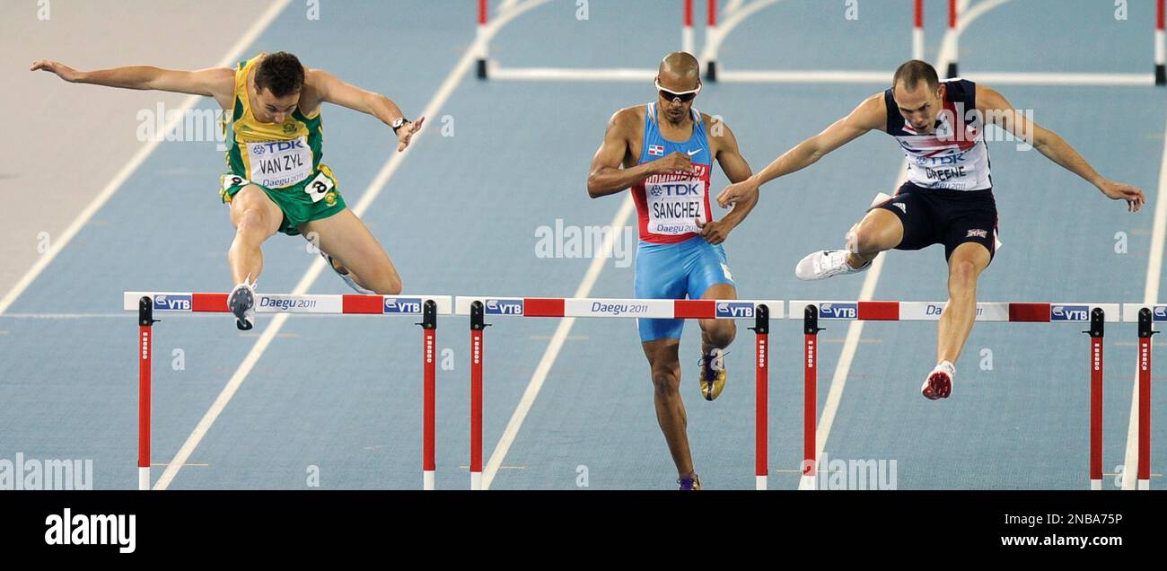 Britain's David Greene, right, clears the last hurdle ahead of Dominica ...