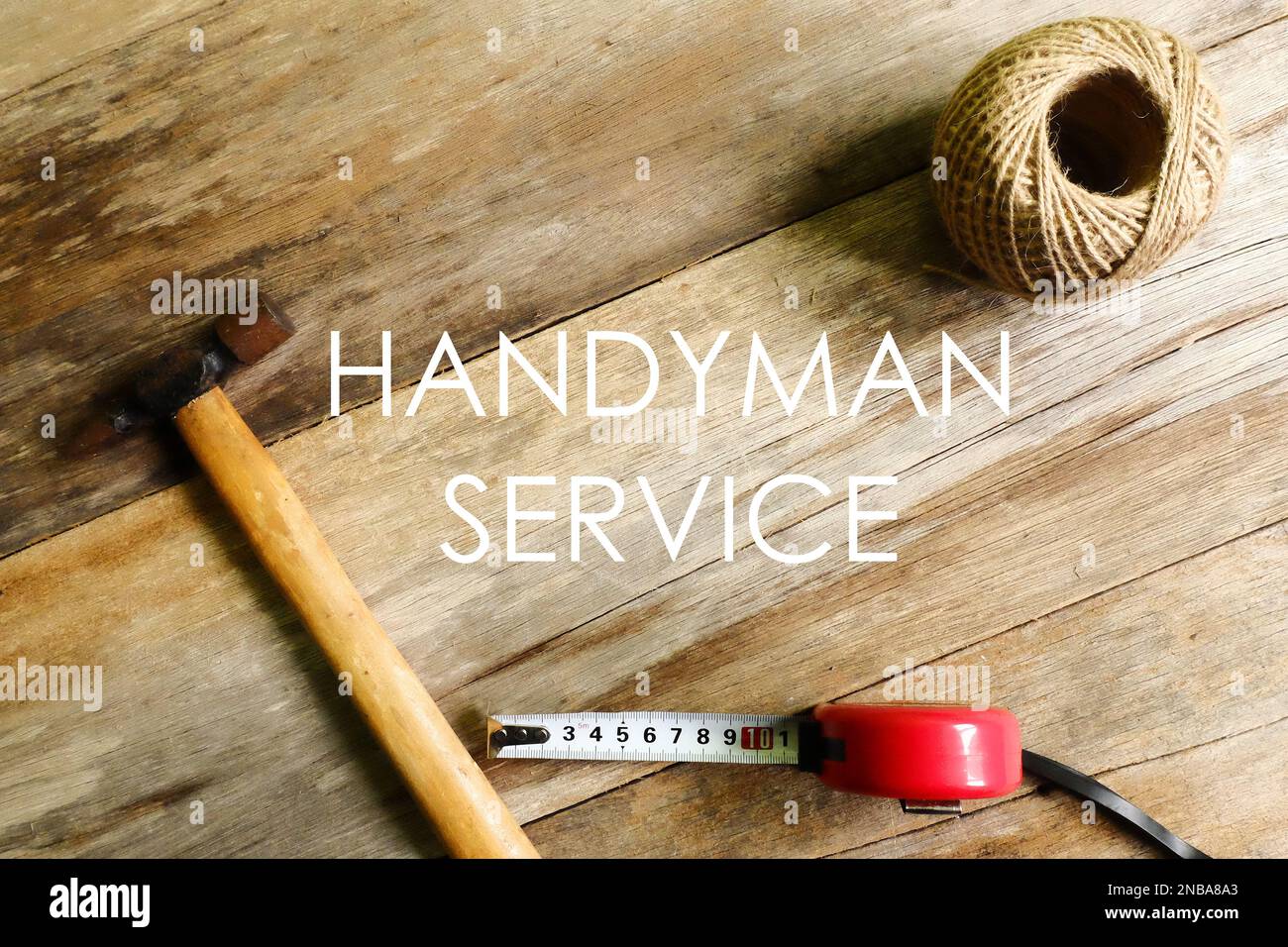 Handyman service written on wooden background with rope,measuring tape ...