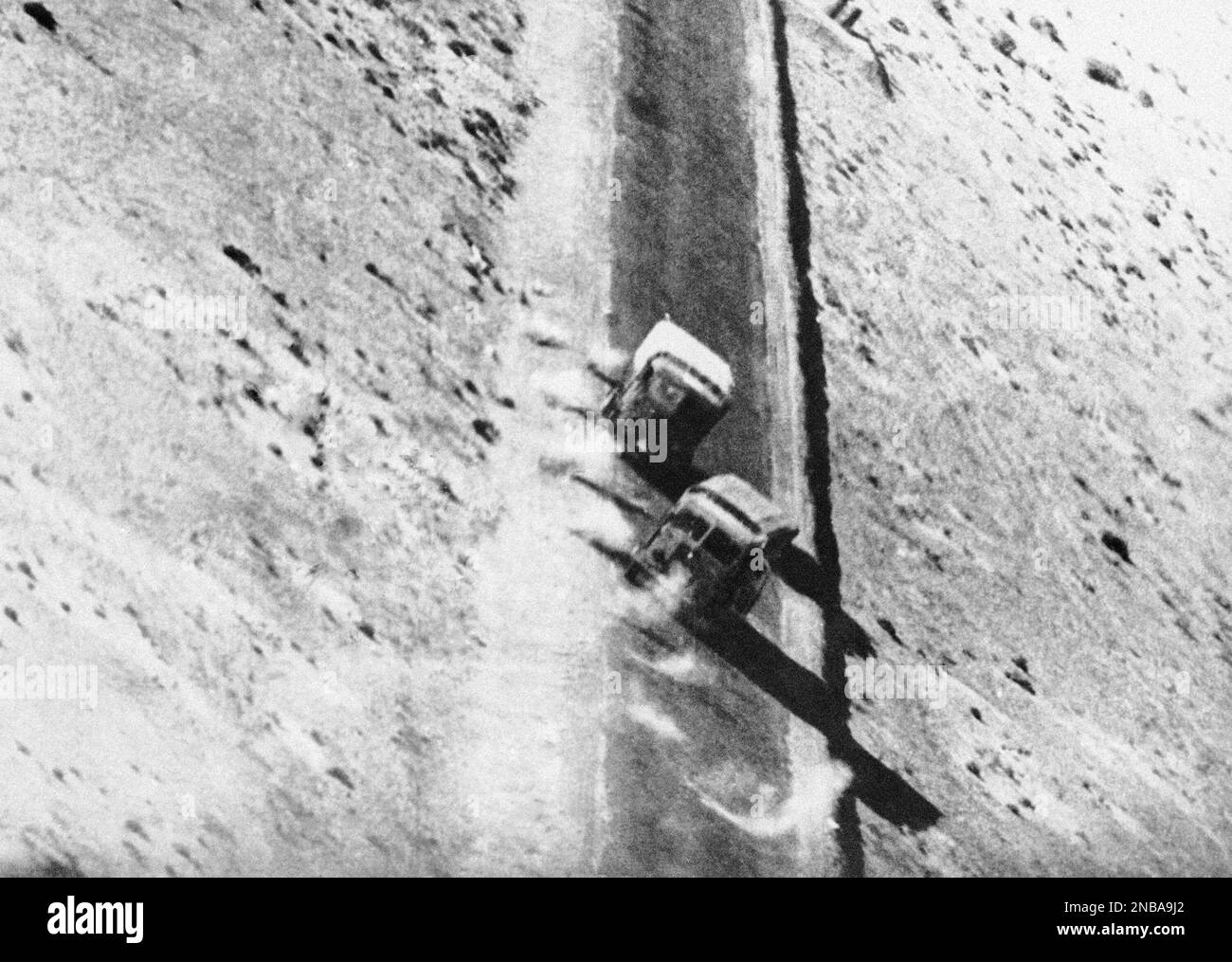 Two enemy lorries careen off the road as they are struck by machine gun ...