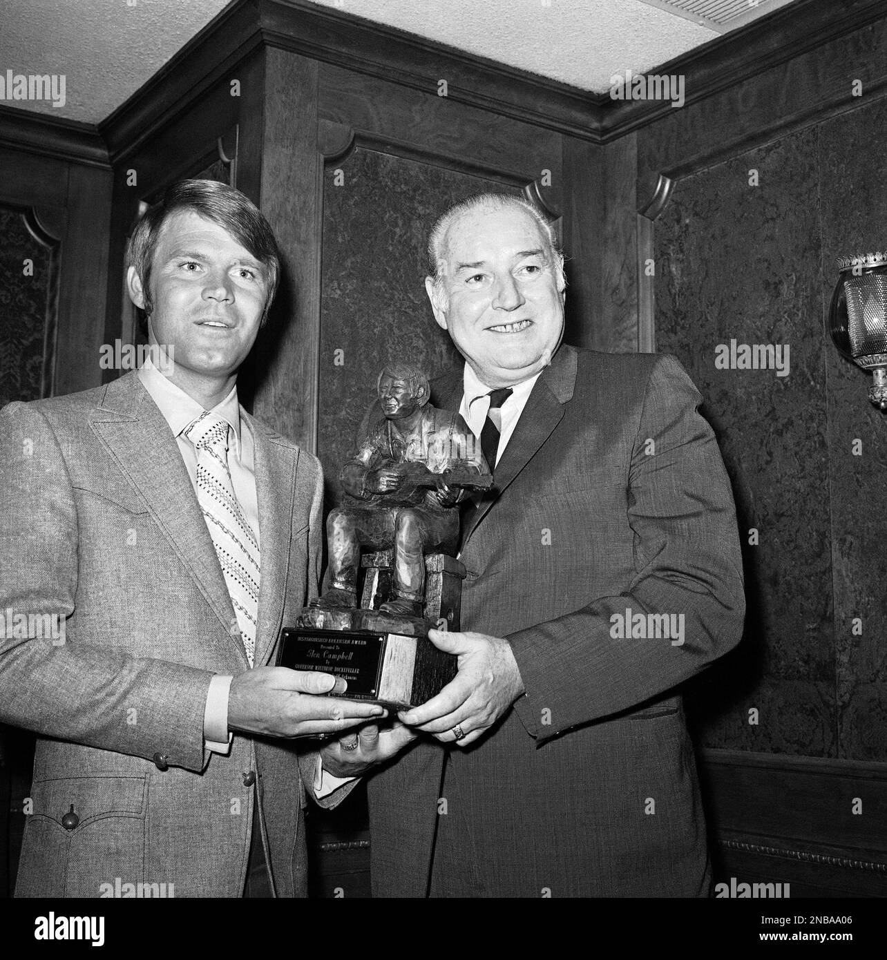 Singer Glen Campbell, left receives carved-wood trophy as a ...
