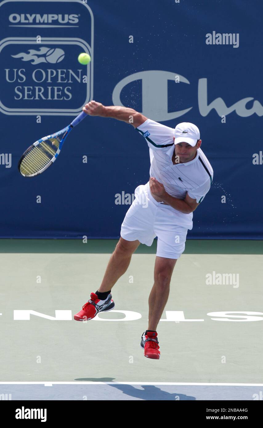 Andy Roddick goes airborne as he returns a shot to John Isner during ...