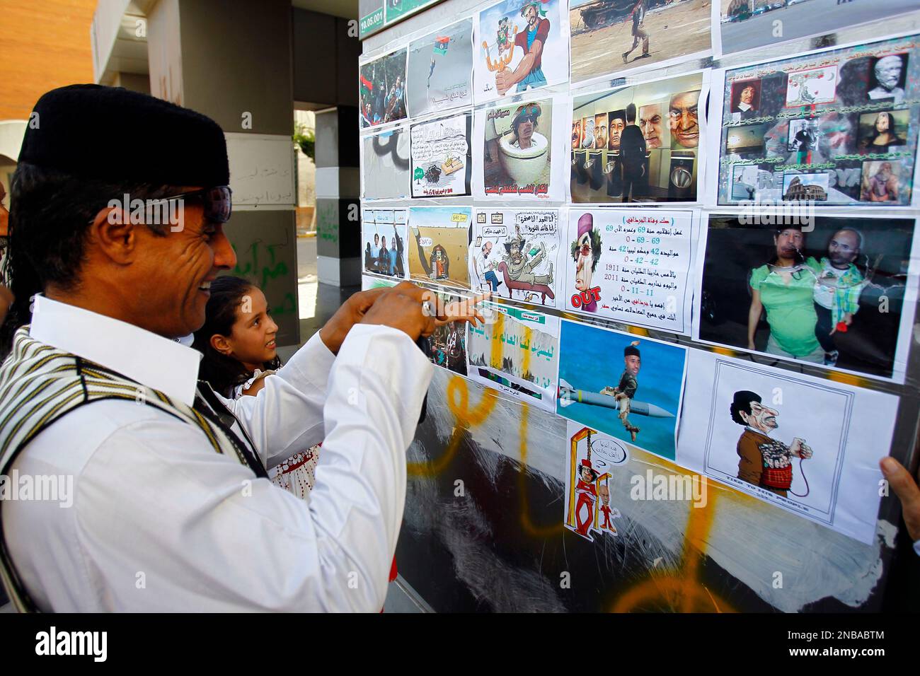 Libyan look at cartoons at the Green square, renamed Martyr's square ...