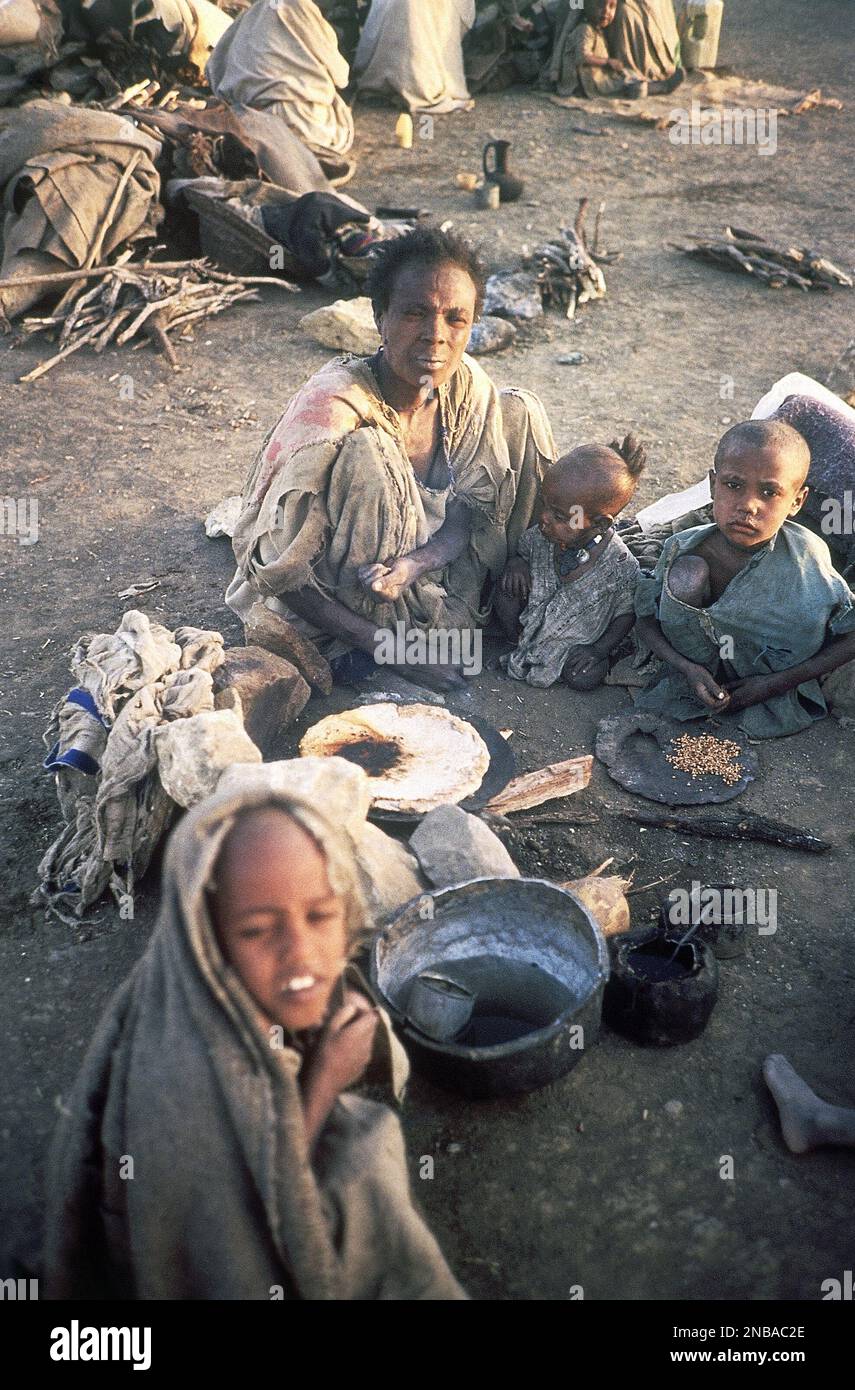An Ethiopian mother and children gathered around a small meal in one of ...