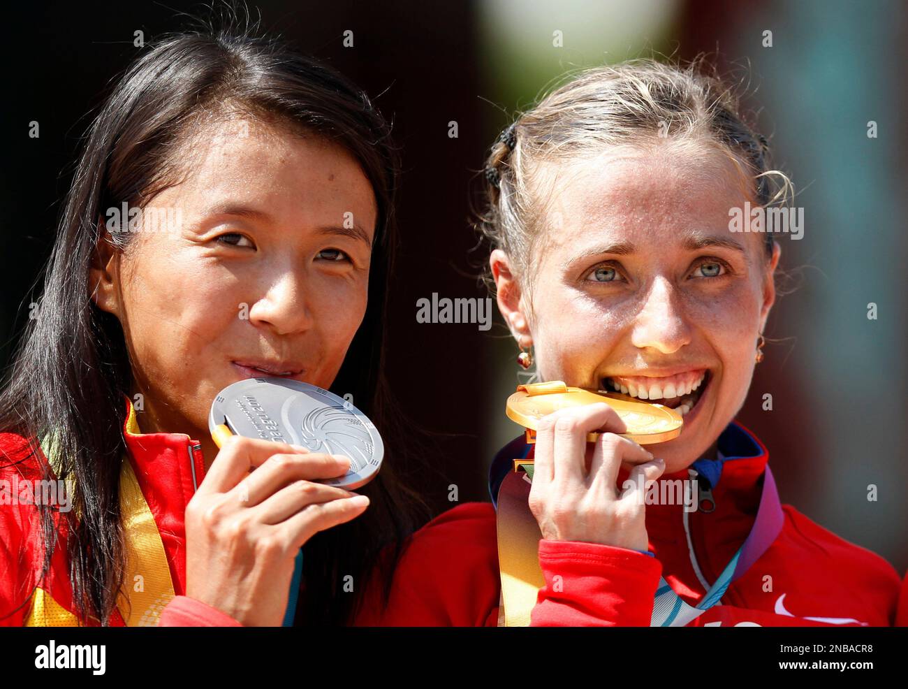 Russia's Olga Kaniskina, right, poses with the gold medal, flanked by ...