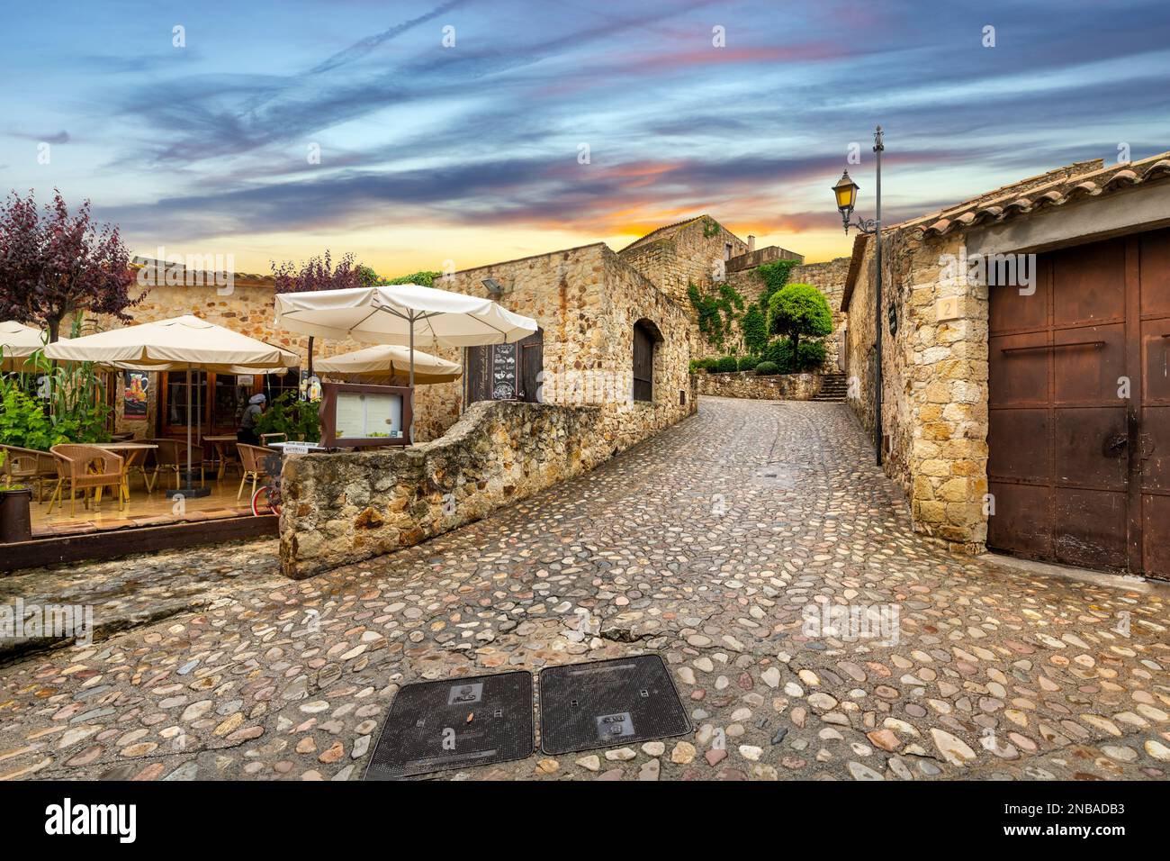 The medieval Spanish village of Pals, Spain, with a sidewalk cafe on it ...