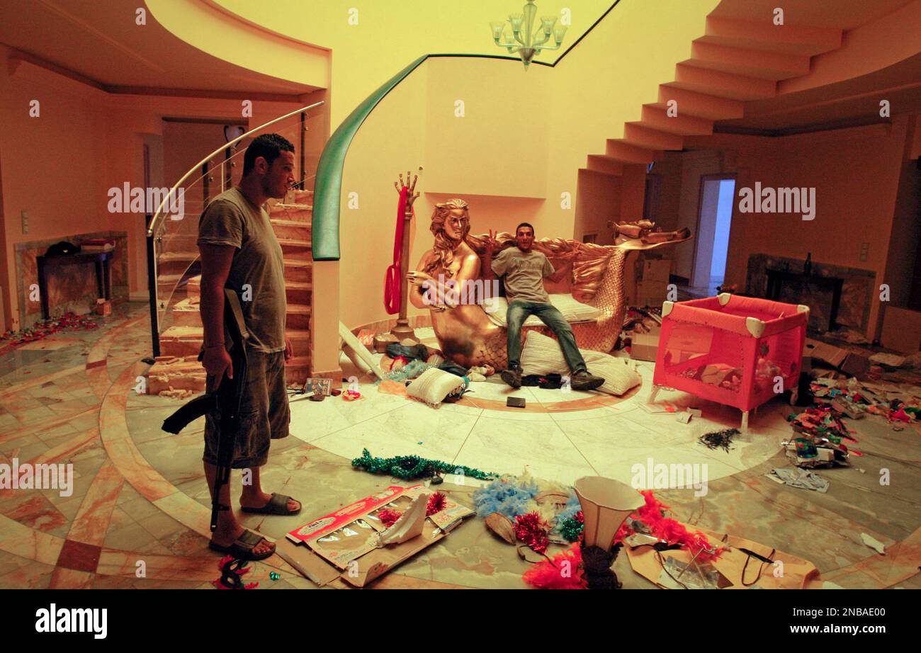 In this Wednesday, Aug. 24, 2011 photo, Libyan rebel fighters sit on a ...