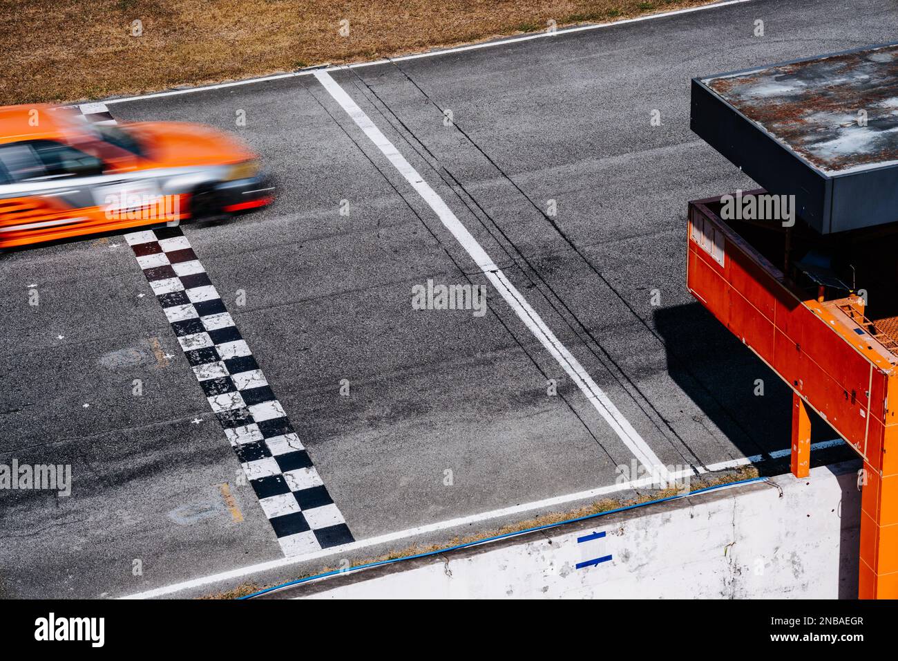 Orange racing car crosses the finish line Stock Photo - Alamy