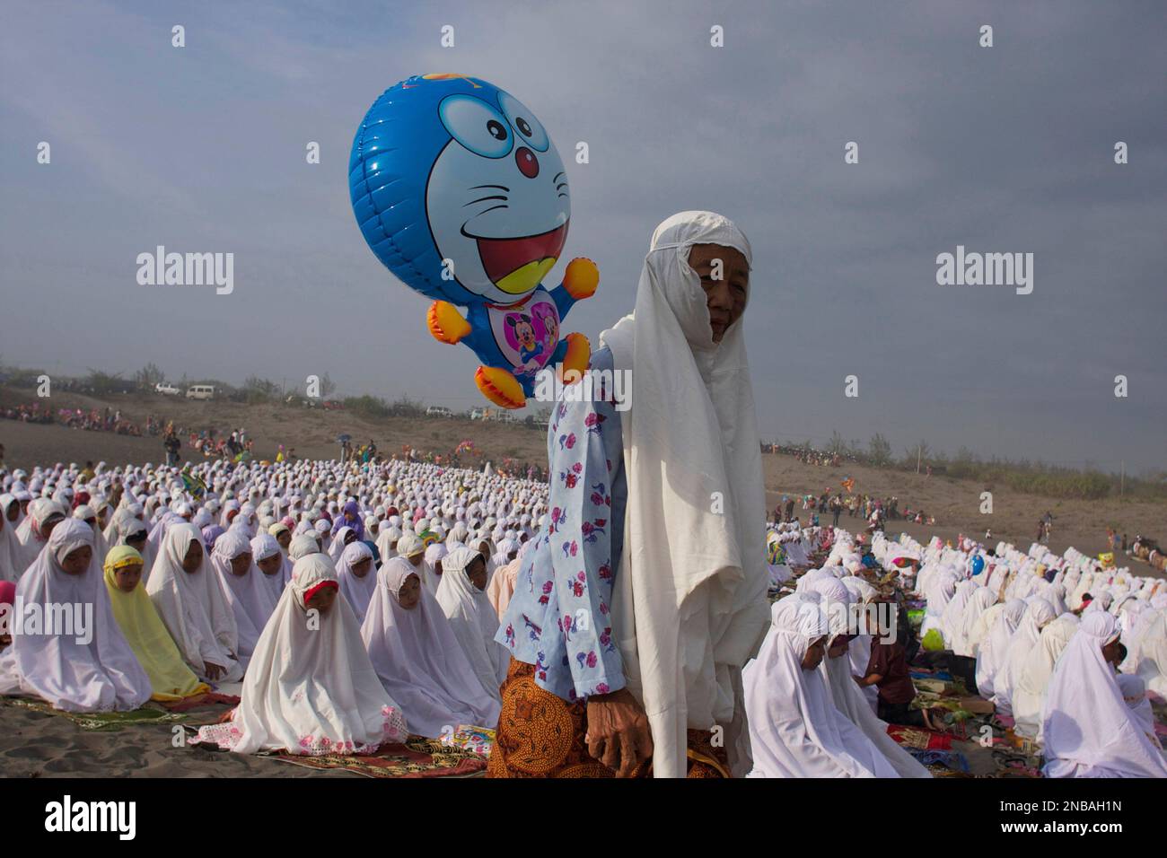 A Muslim woman holds a balloon of Japanese cartoon character Doraemon ...