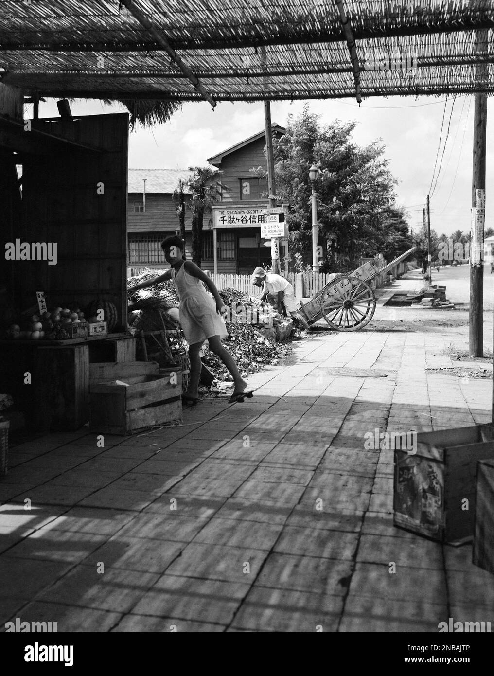 Looking from under a fruit store canopy as workmen remove war-time ...