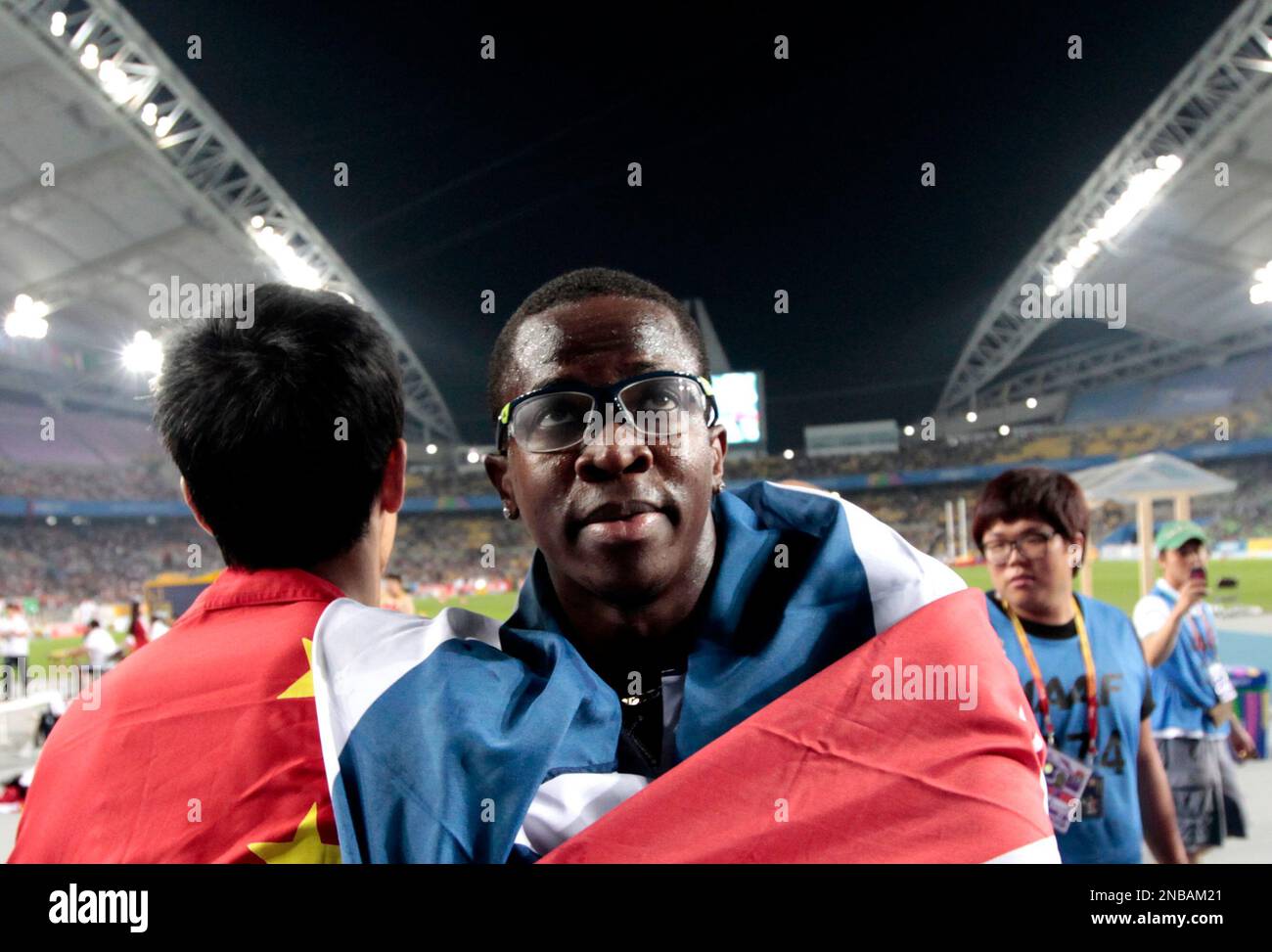 Cuba's Dayron Robles, center, walks with Cuban flag, after crossing the ...