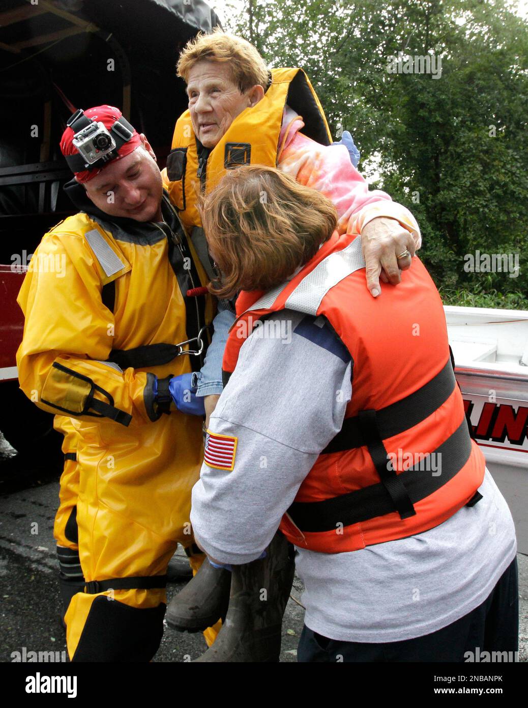 Shirley Larkin, 74, center, is brought down from a boat by Alban Ameti ...