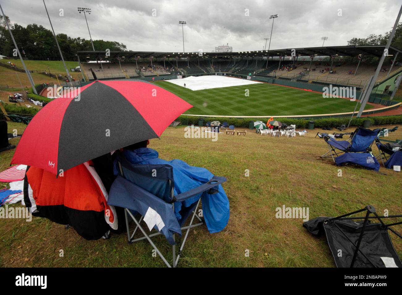 Little League baseball fans sit on the hillside overlooking Lamade ...