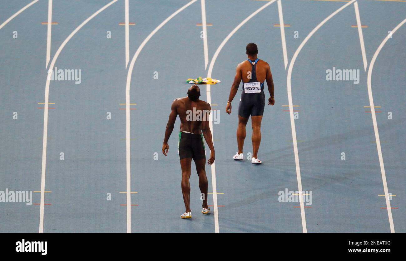Jamaica's Usain Bolt, left, reacts after being disqualified for a false ...