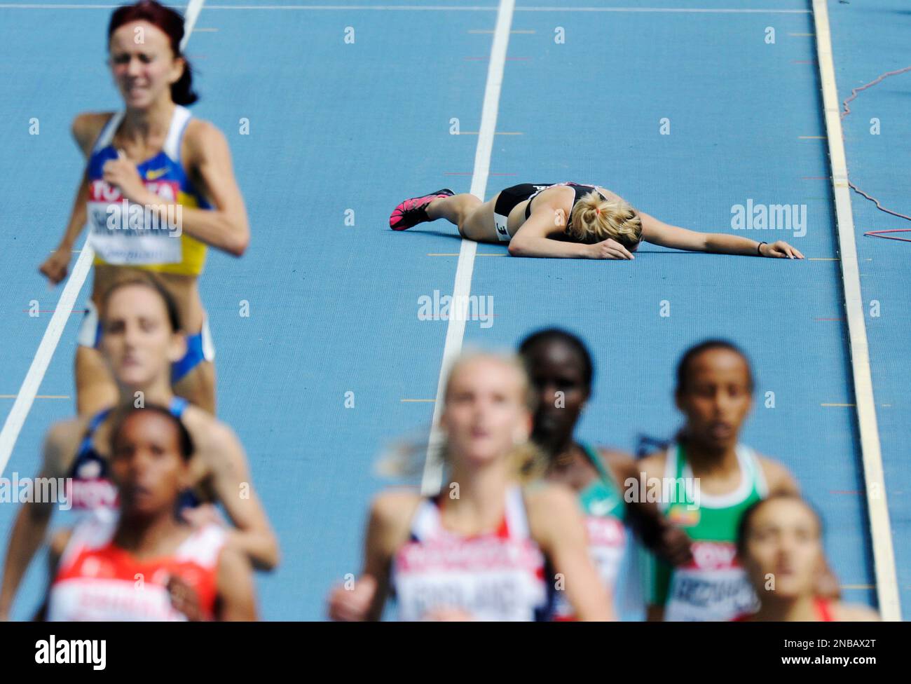 New Zealand's Nikki Hamblin, back, lies on the track as the pack runs ...