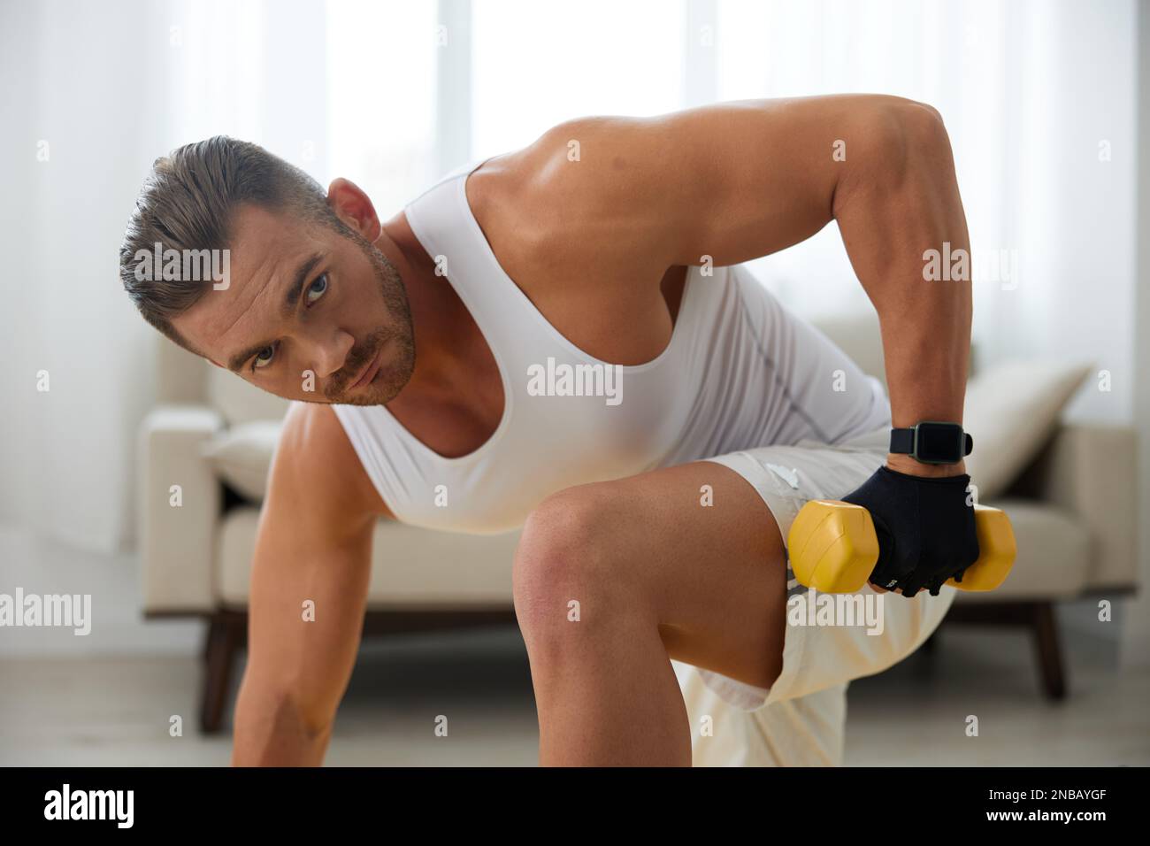 Man sports home training on the floor on a mat with dumbbells ...