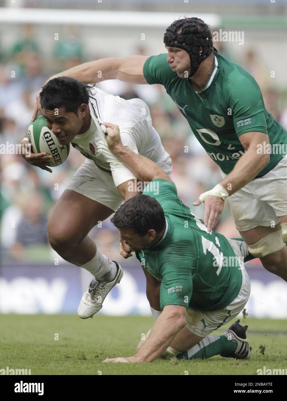 England's Manu Tuilagi, left, is tackled by Ireland's Denis Leamy ...