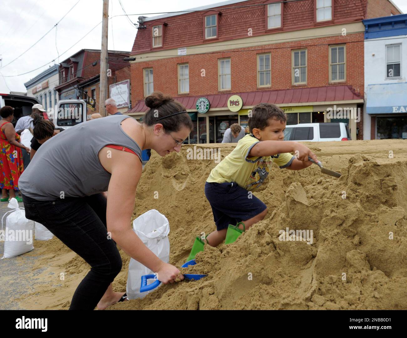 Cathryn Scarano and her son Michael fill bags of sand in preparation ...